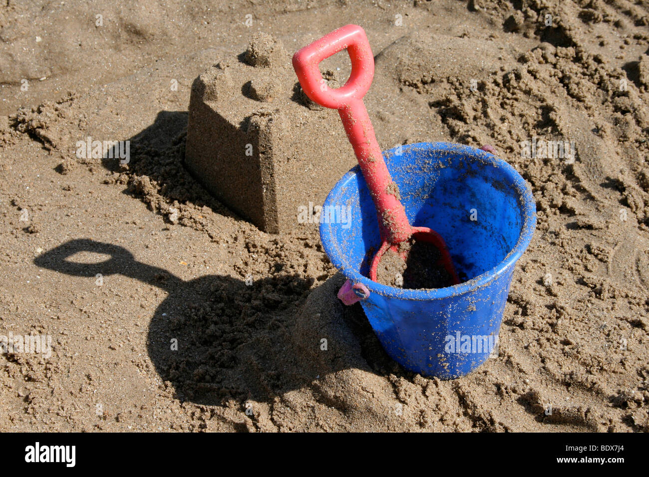 Bucket and spade with sandcastle Stock Photo - Alamy