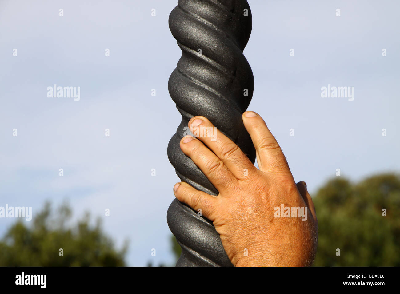 A man's hand leaning on a spiral lamp post Stock Photo - Alamy