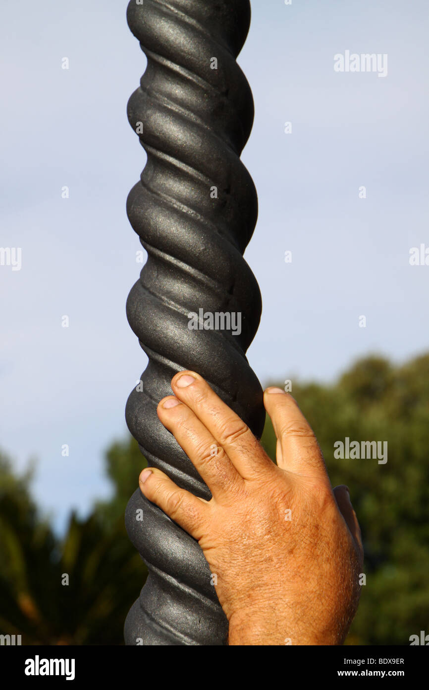 A man's hand leaning on a spiral lamp post Stock Photo - Alamy