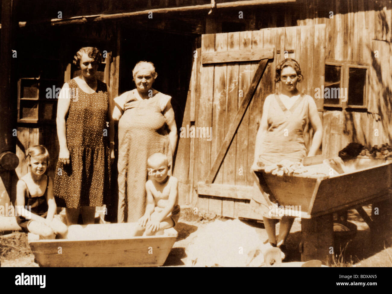 Women washing their children in a washing trough, historic photograph ...
