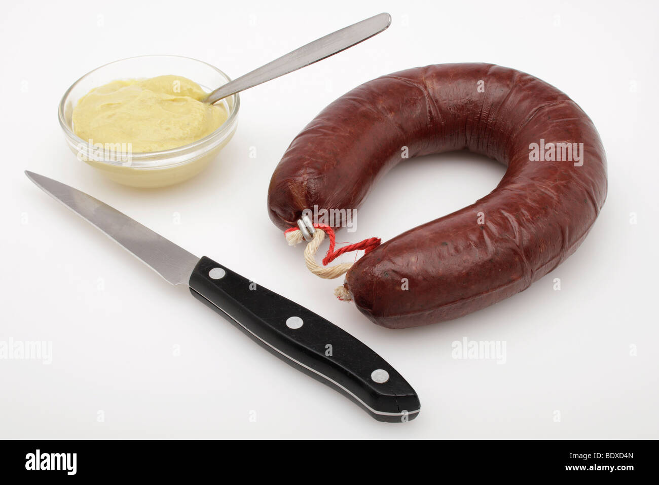Ring of black pudding with mustard and knife Stock Photo - Alamy