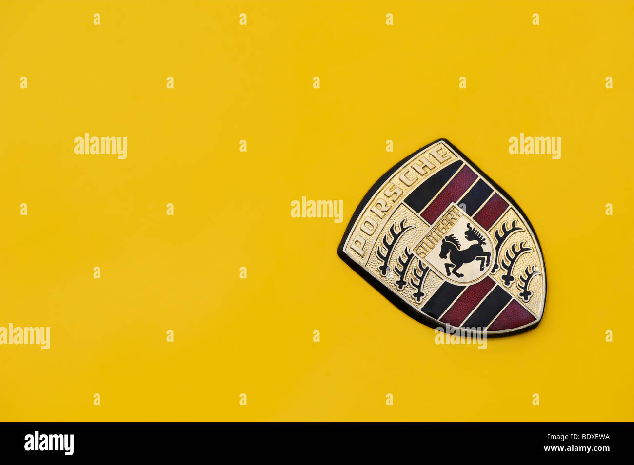 Porsche car badge on yellow Stock Photo - Alamy