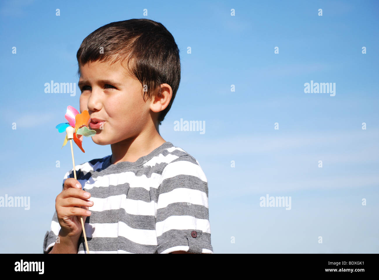 Young boy playing with a hand held windmill Stock Photo - Alamy