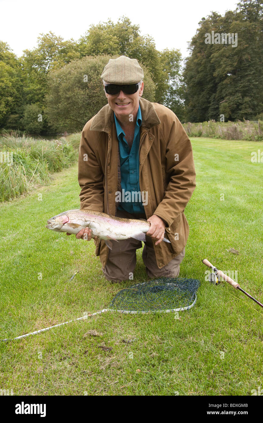Trout fly fisherman with a large 6lb rainbow trout, Avington Fishery ...