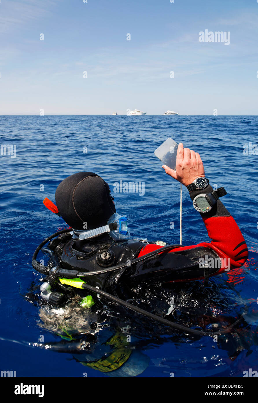 Drifting diver at sea is trying to get the attention of people on dive ...