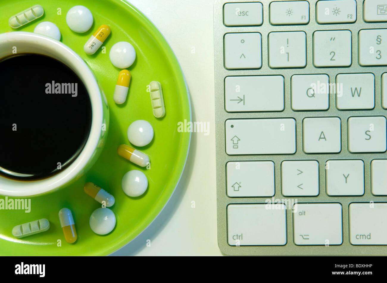 Uppers and psychotropic drugs next to a computer keyboard, symbolic ...