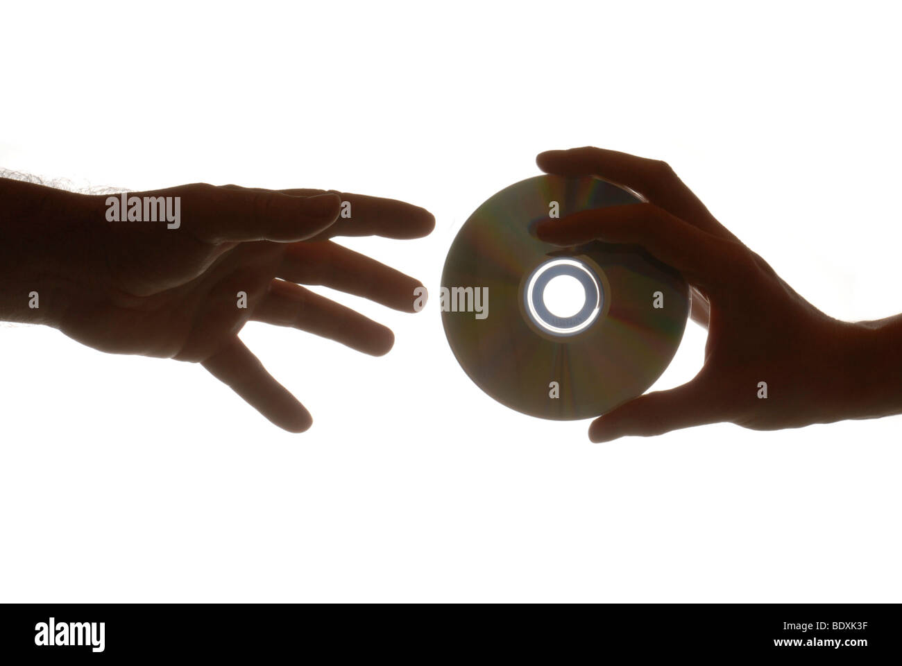 Female hand giving a CD to a male hand, symbolic picture for data theft ...