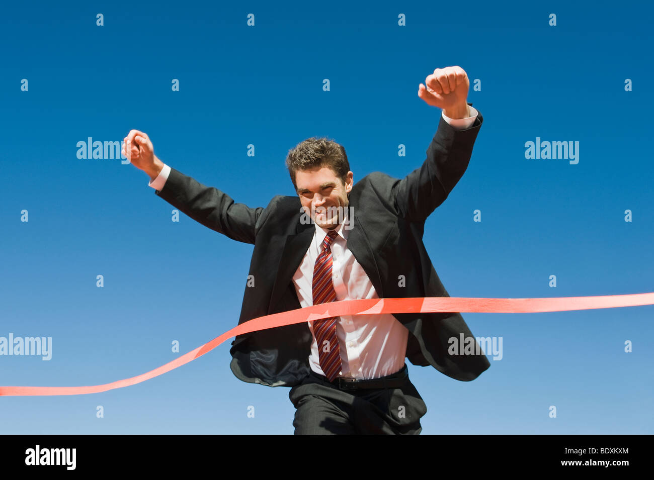 Businessman Crossing the Winning Line Stock Photo - Alamy