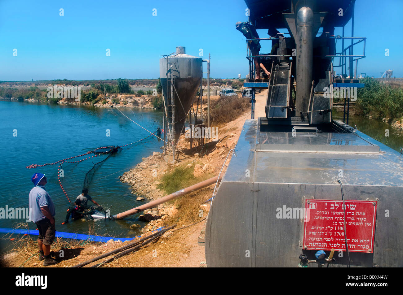 Israel, Coastal Plains, Kibbutz Maagan Michael, Harvesting fish from an ...