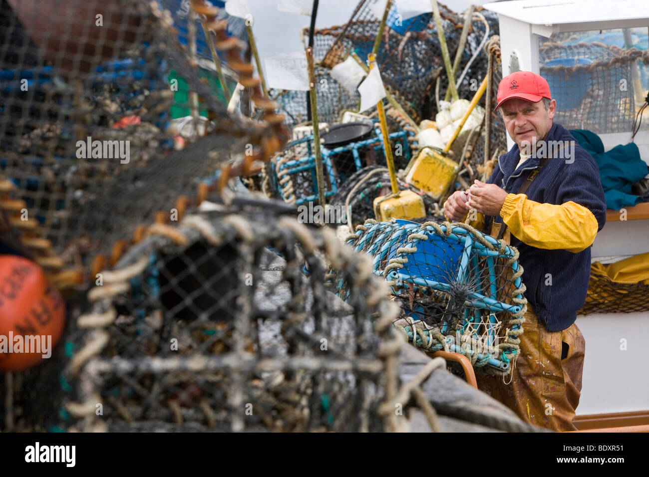 Fisherman loading loobster baskets on his boat before going out fishing ...