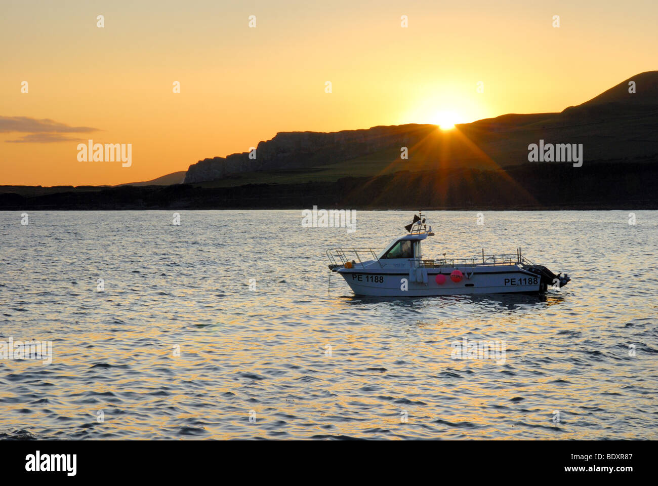 Sunset with small fishing boat Kimmeridge Bay Dorset Stock Photo - Alamy