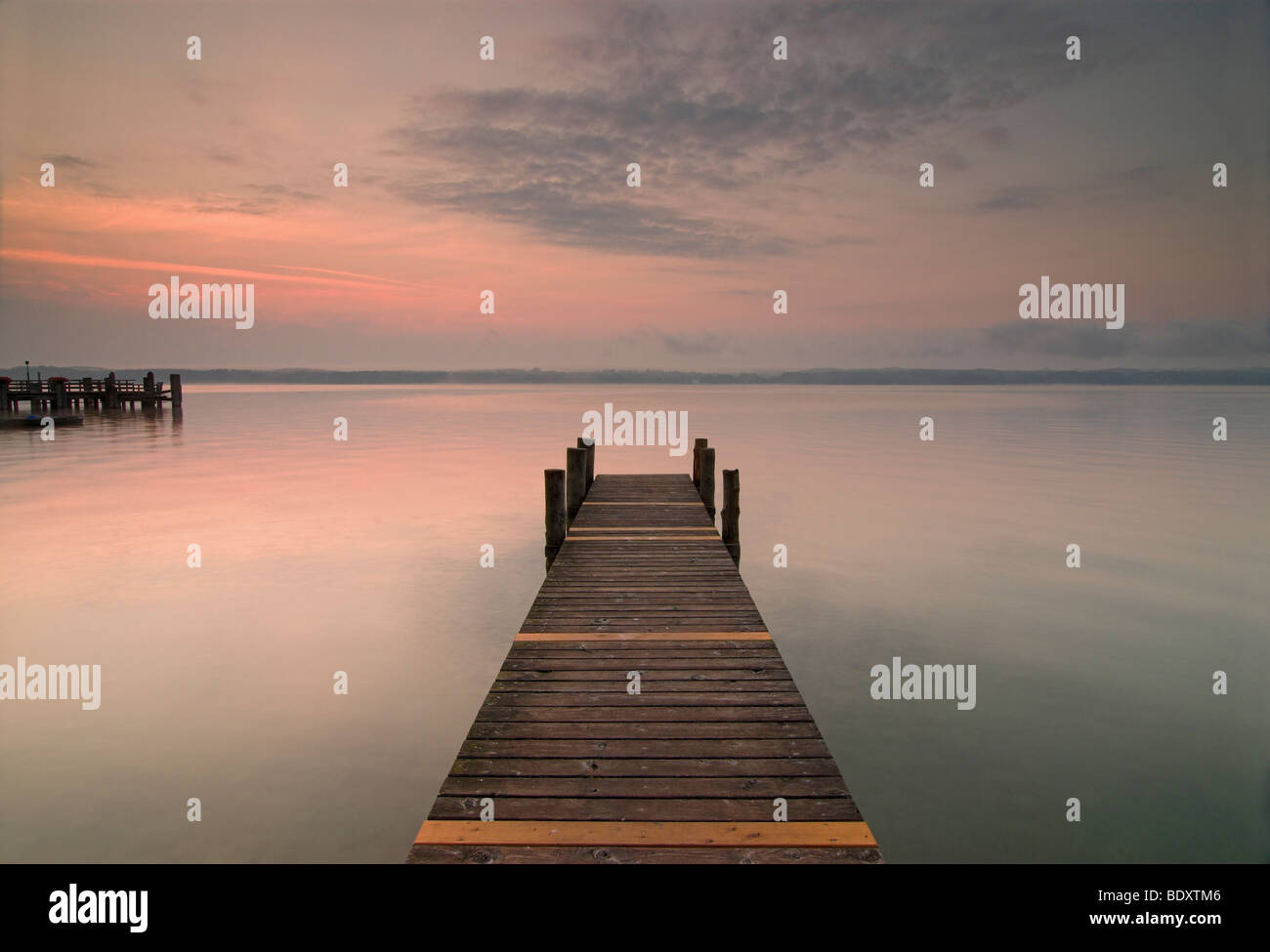 Sun rising over a pier in the calm Lake Starnberg, Bavaria, Germany ...