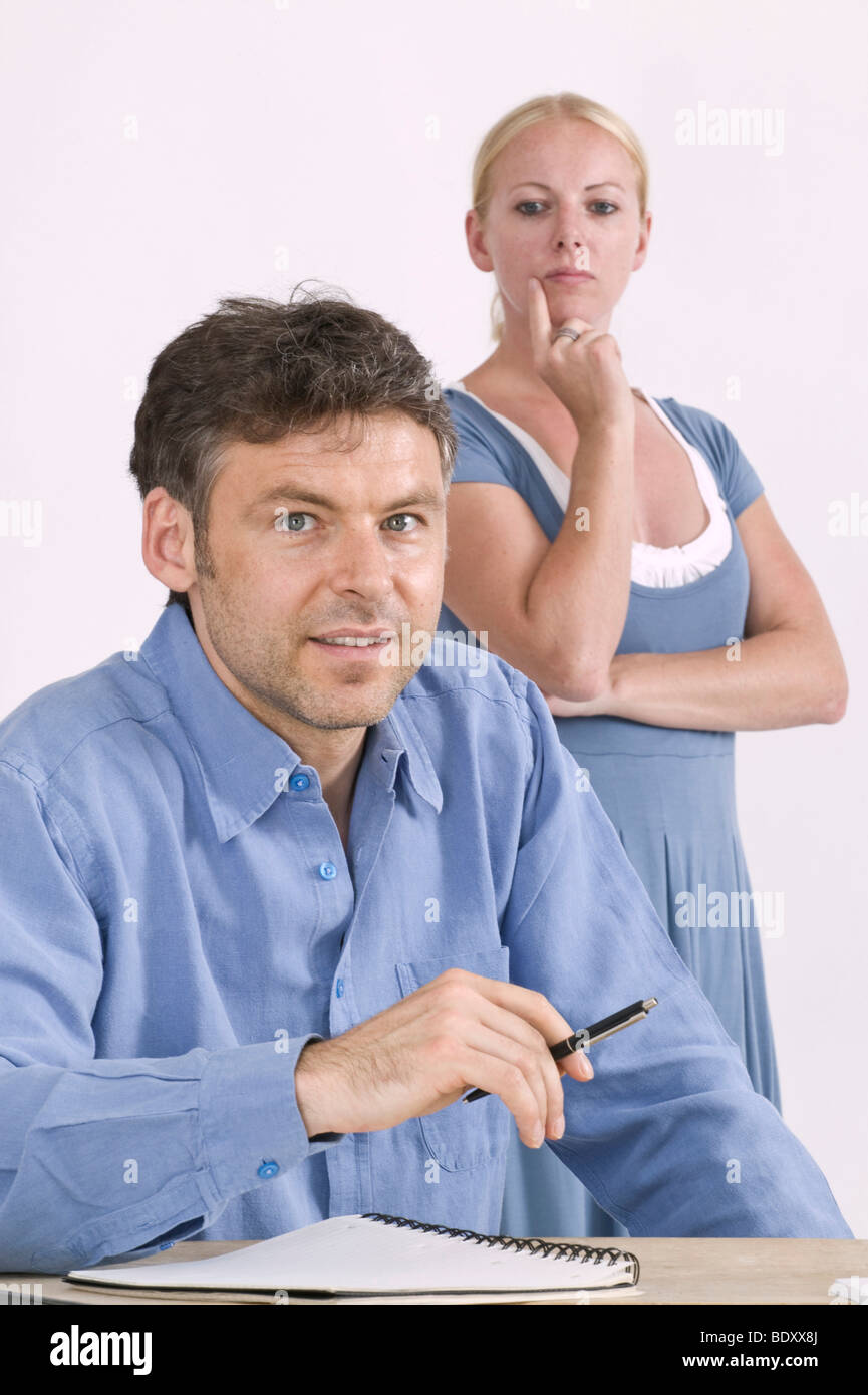 Colleagues at work in an office, woman looking interested, standing ...