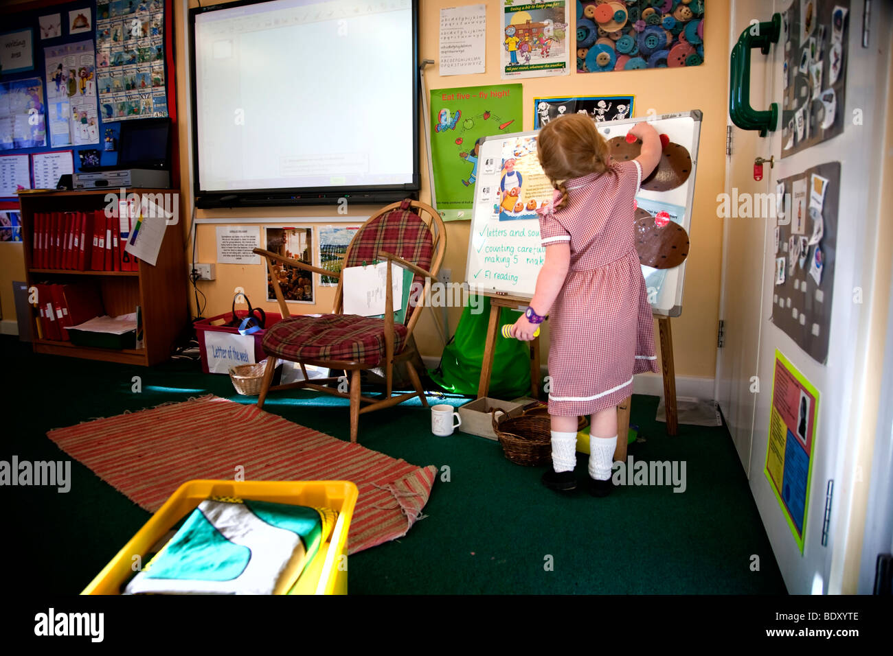 4 year old girl at whiteboard in foundation stage classroom in uk ...