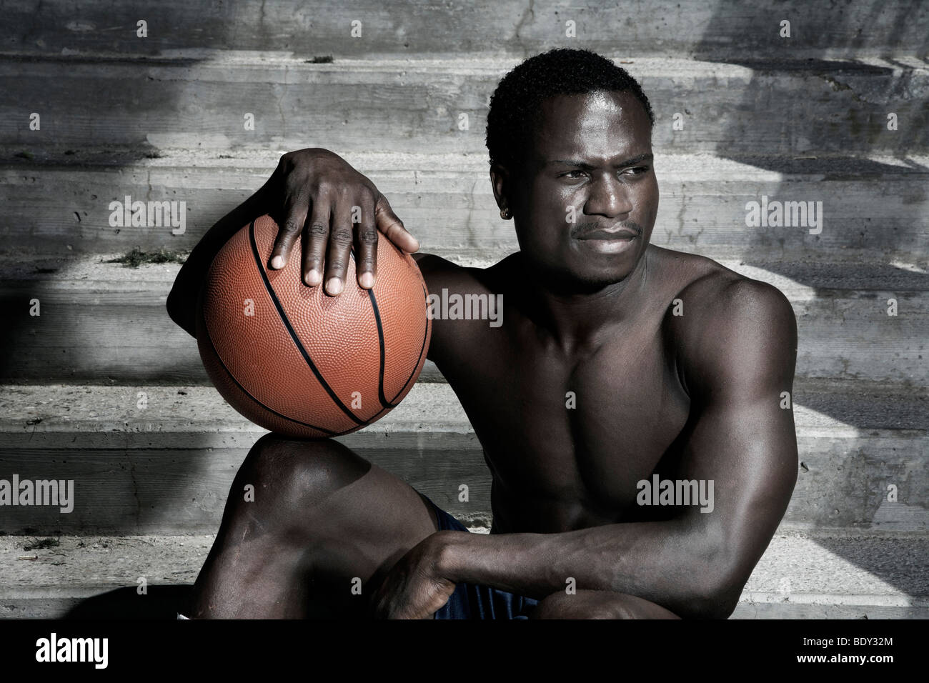 Dark-skinned basketball player sitting on stairs, portrait Stock Photo ...