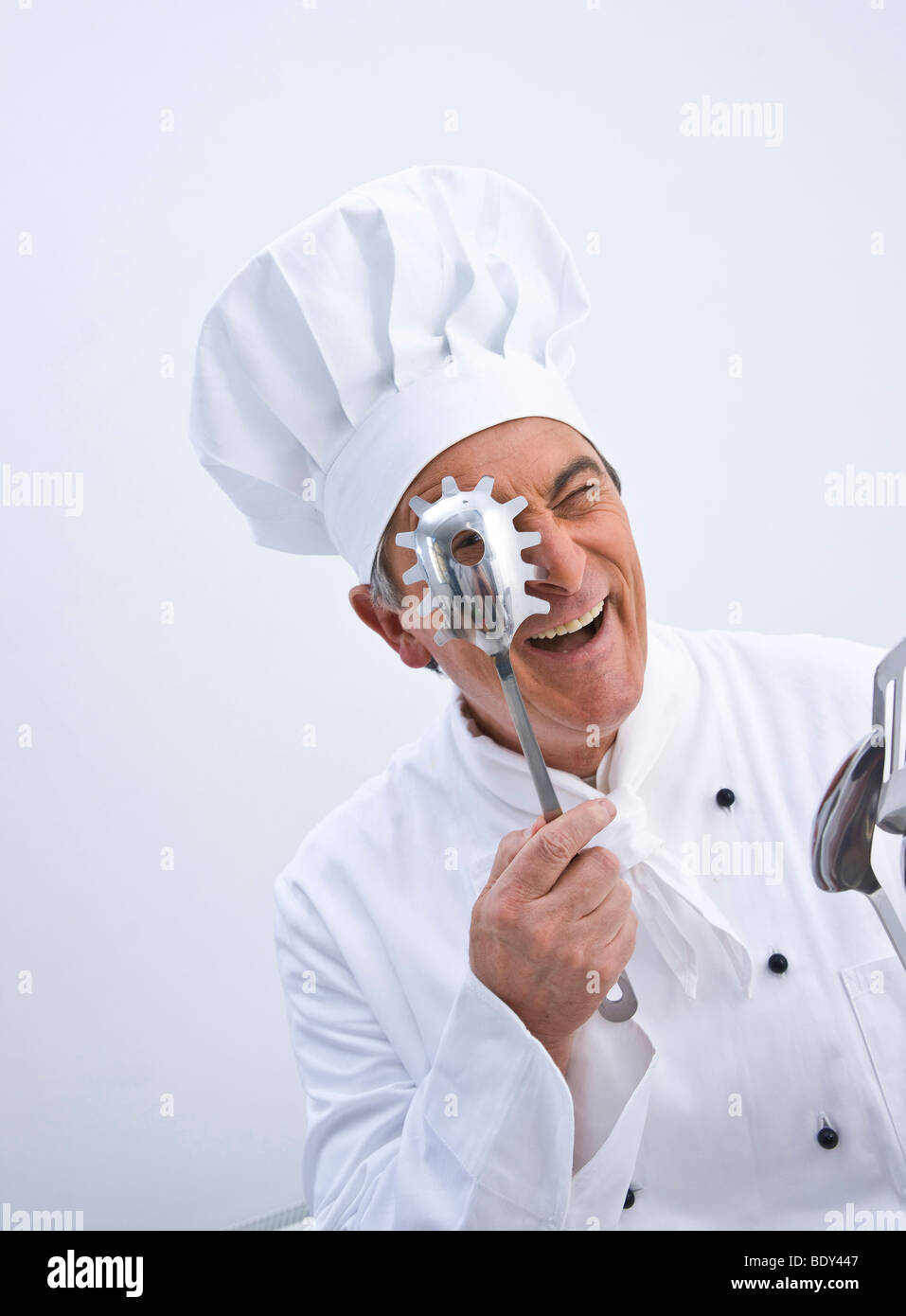 Chef wearing a chef's hat holding cooking utensils in his hands Stock ...