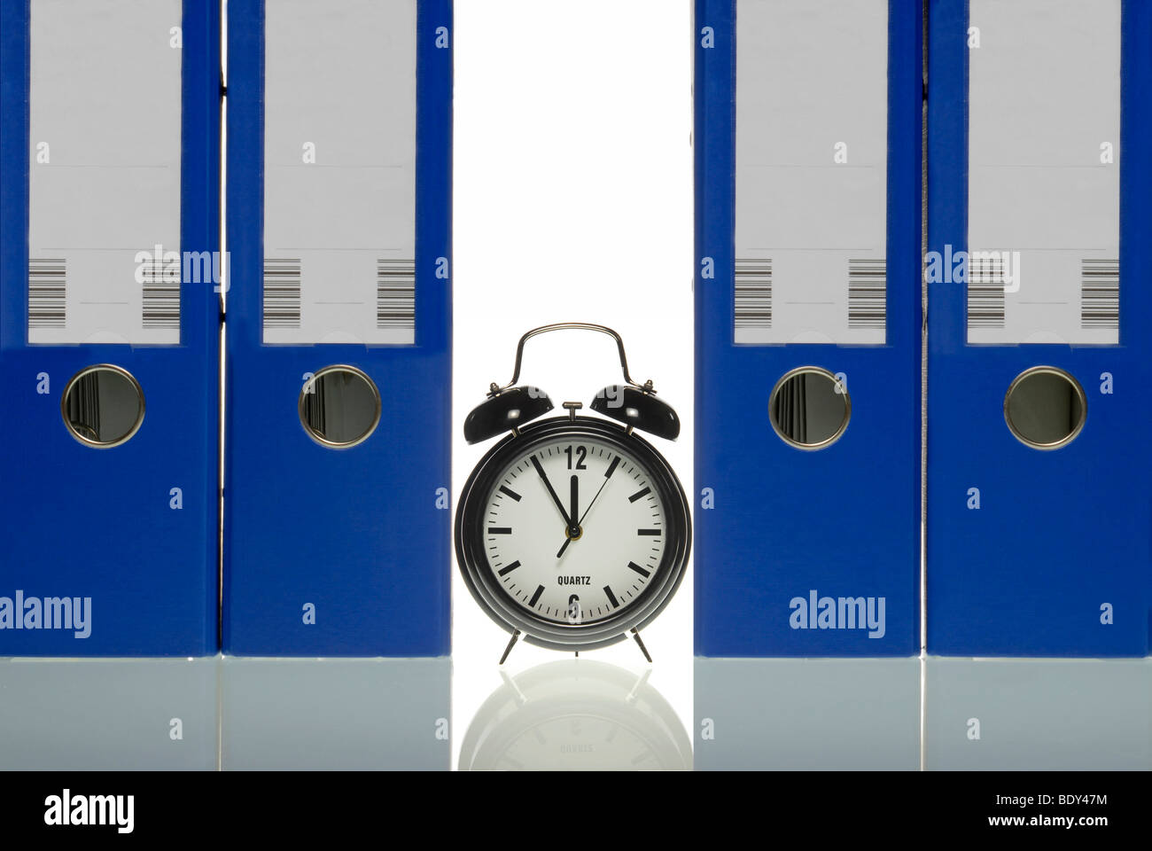 Alarm clock between folders Stock Photo - Alamy