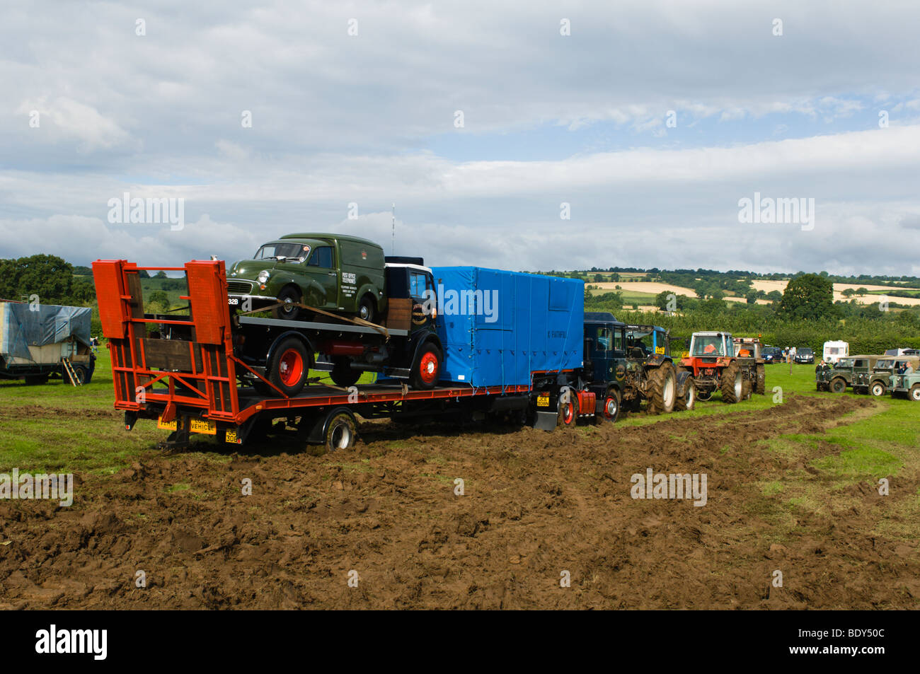 Agricultural tractors towing lorry through muddy field Stock Photo - Alamy