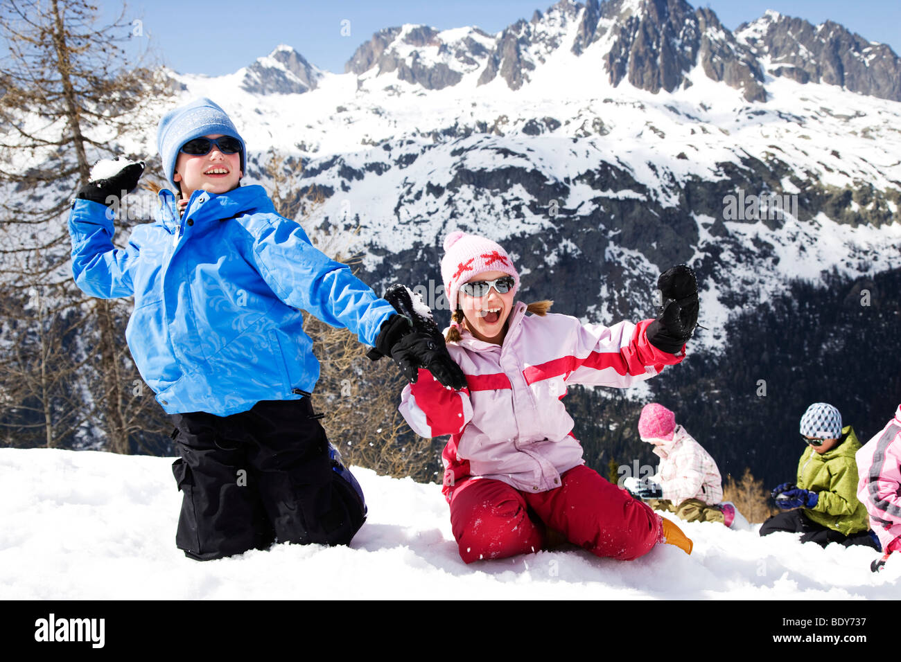 Two kids throwing snow Stock Photo - Alamy
