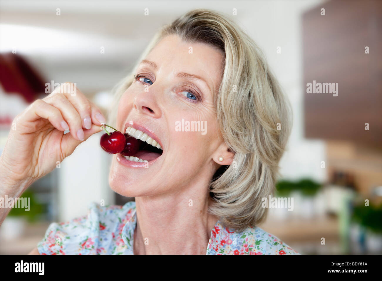 Senior Woman Eating Cherries Stock Photo - Alamy