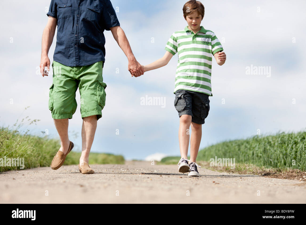 Father and son walking down a road Stock Photo - Alamy