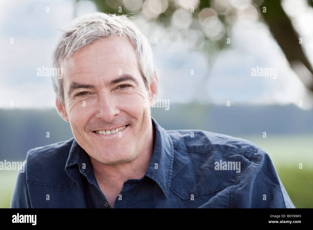 man sitting smiling at viewer Stock Photo - Alamy