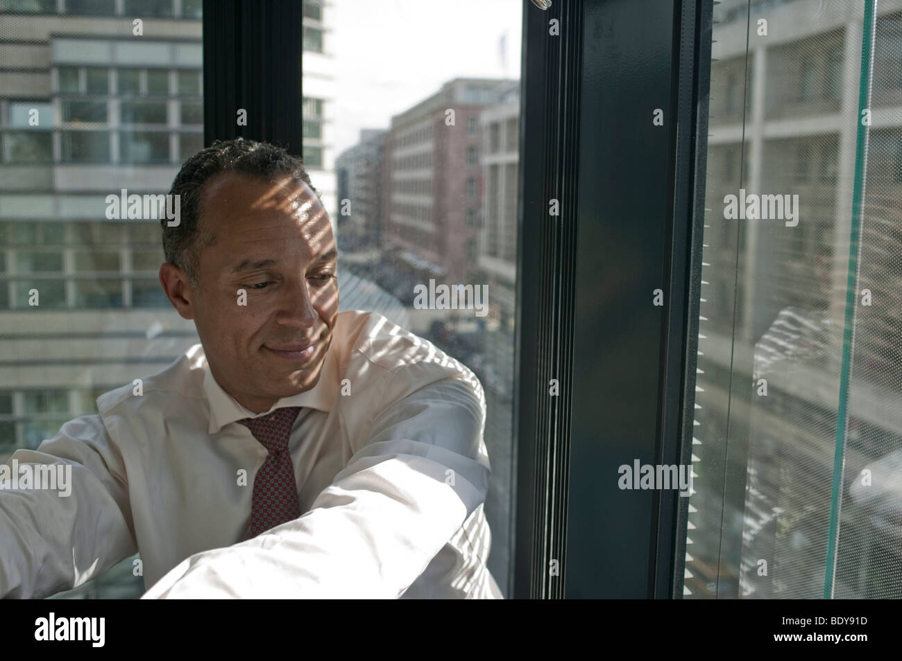 man leaning at window smiling Stock Photo - Alamy