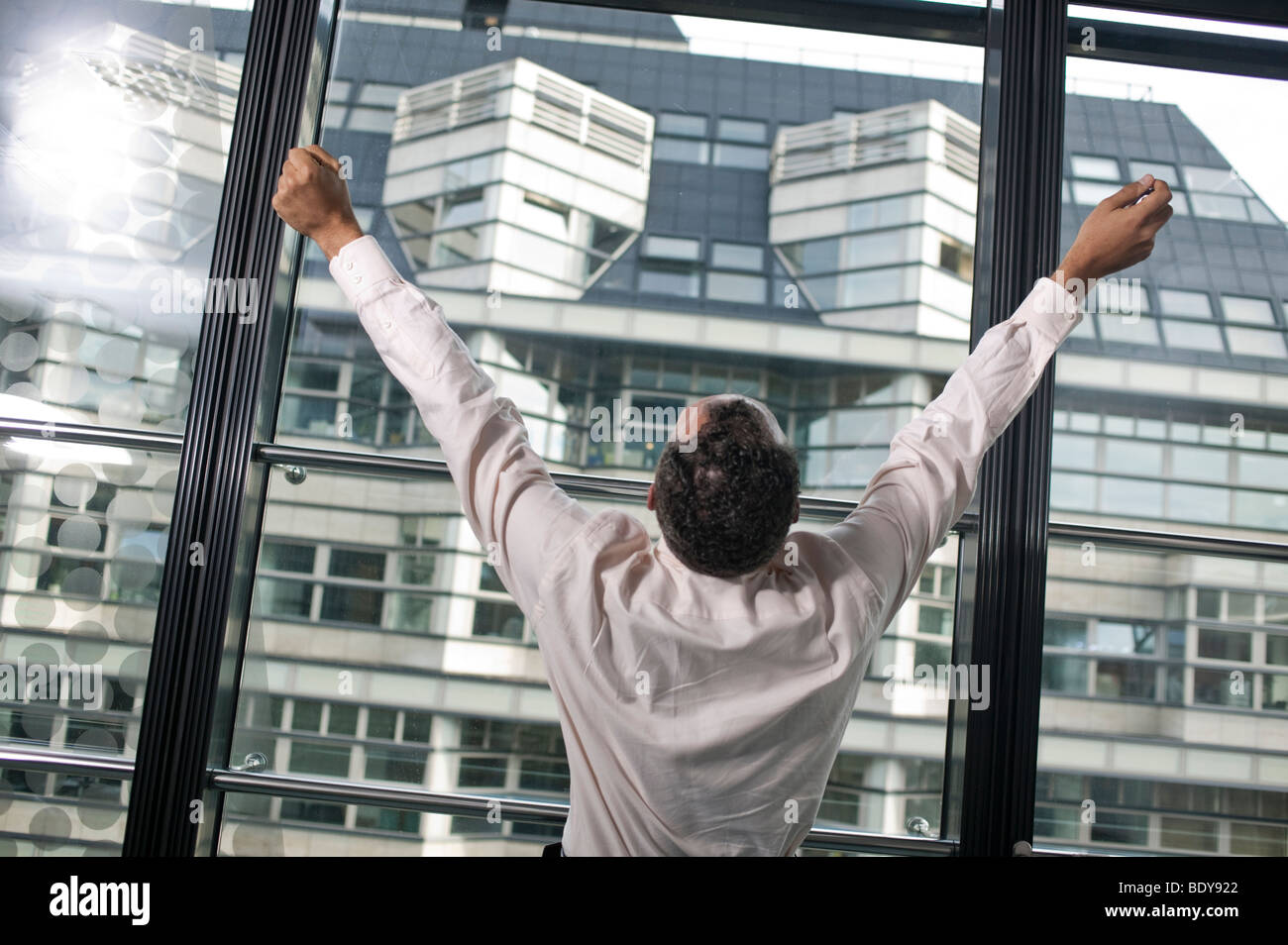 man at window with raised arms Stock Photo - Alamy