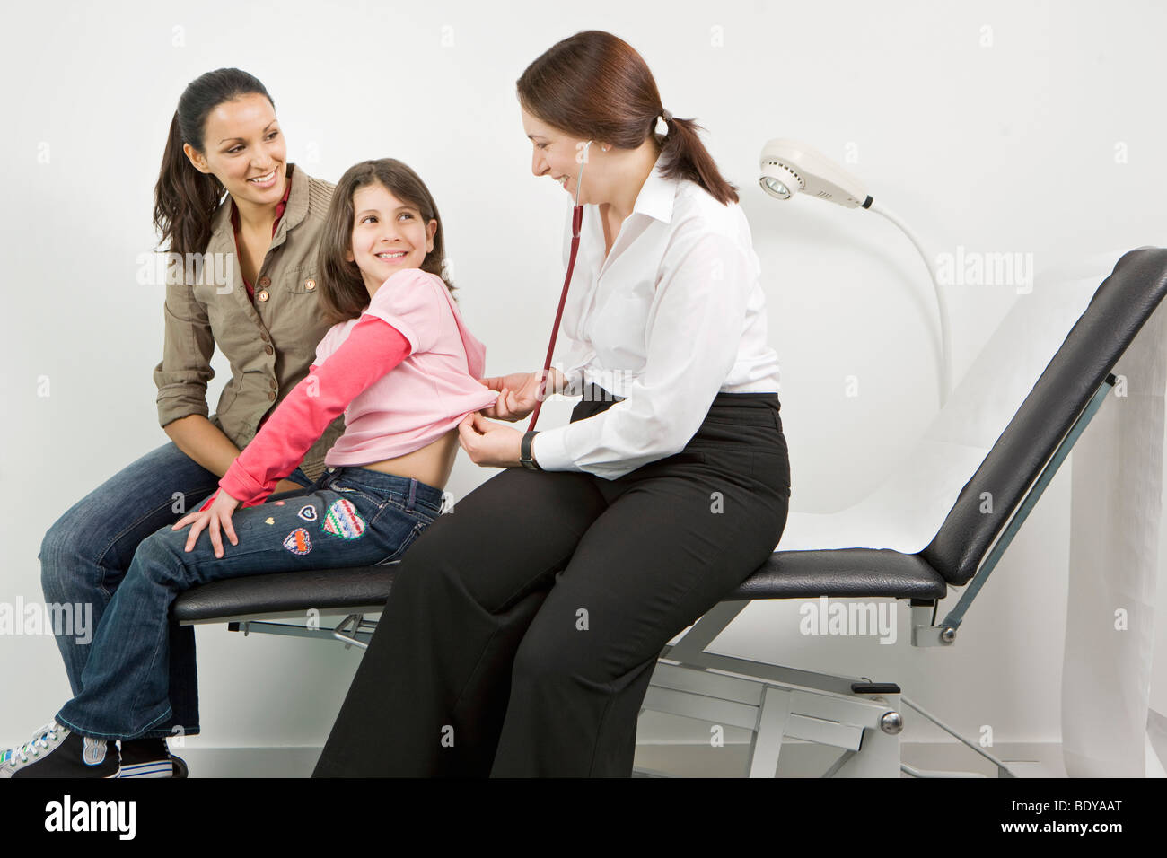 A female doctor looking at a young girl Stock Photo - Alamy