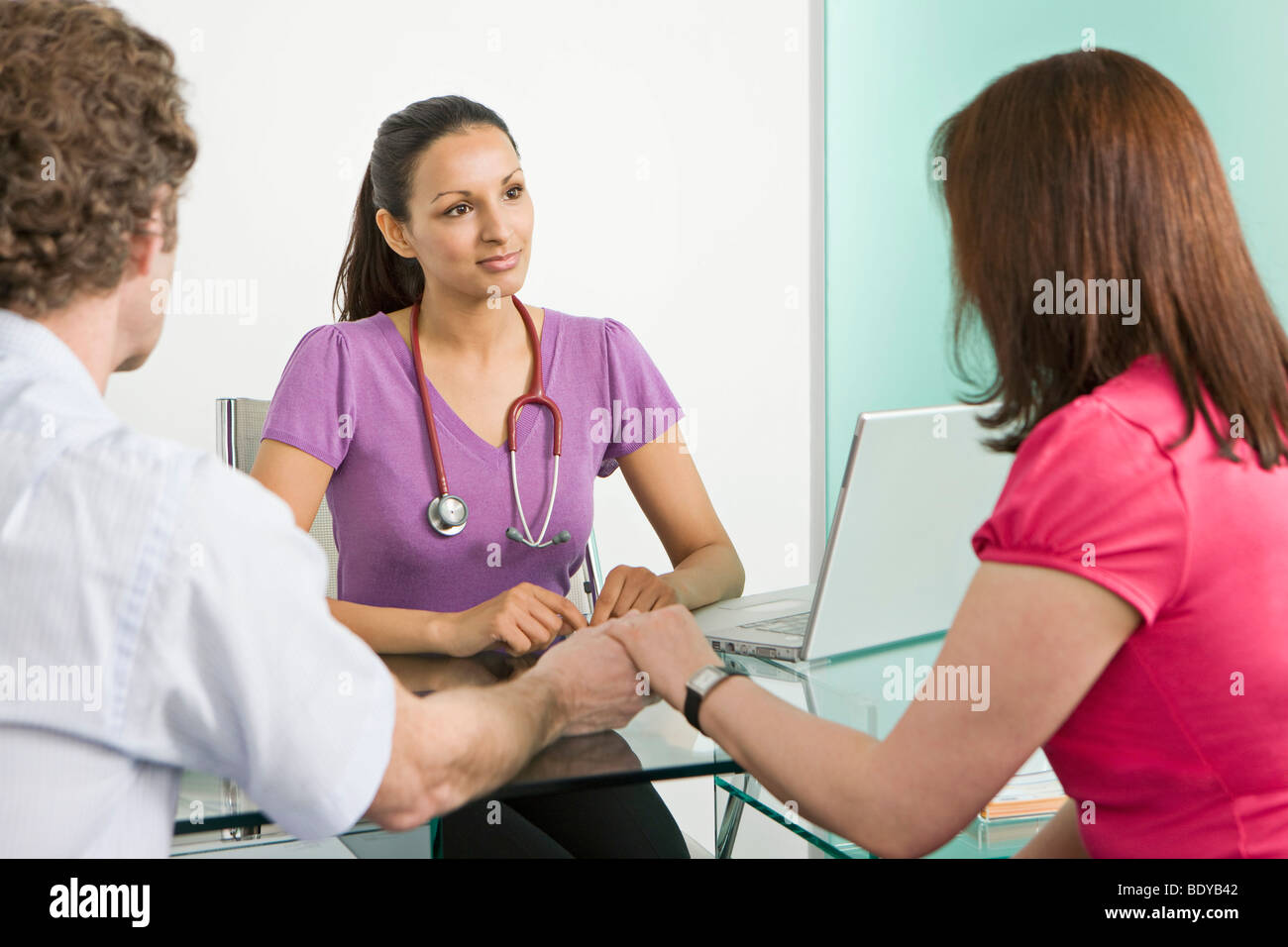 A female doctor with a couple Stock Photo - Alamy