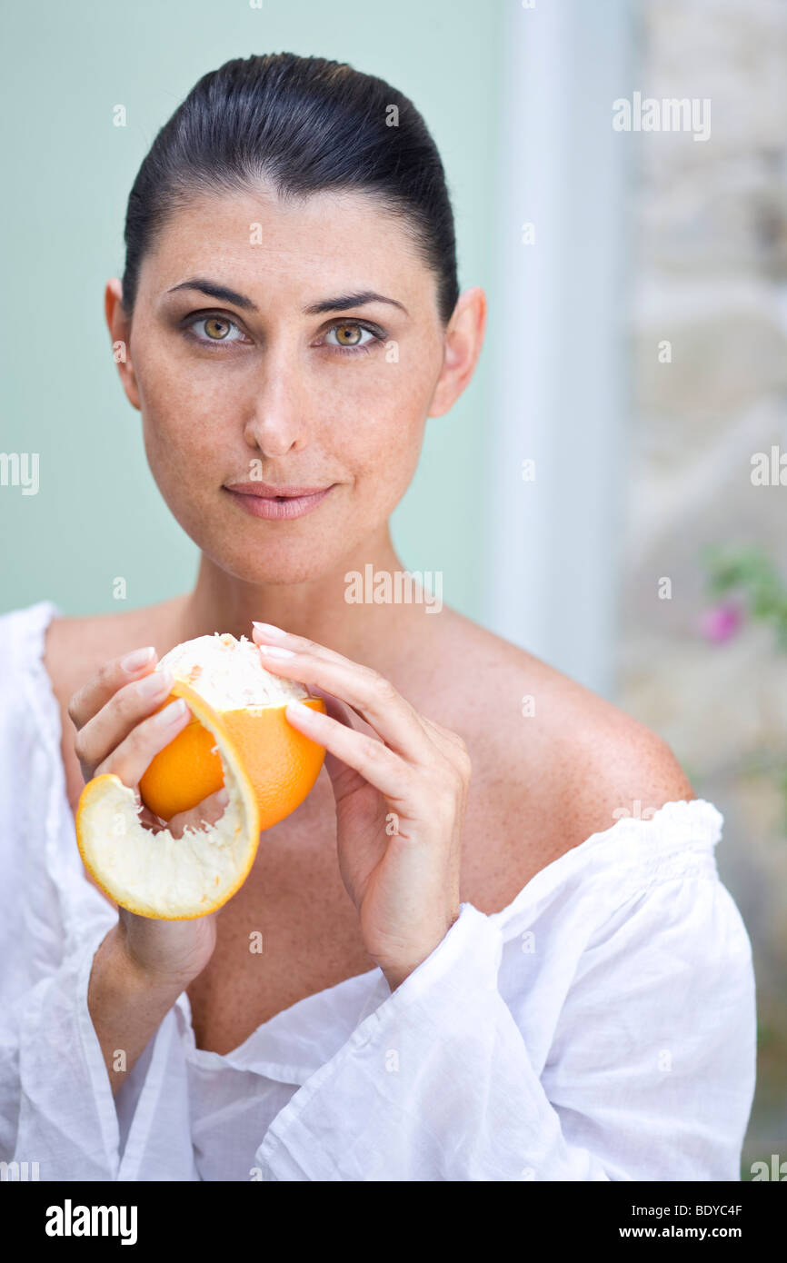 A female beauty peeling an orange Stock Photo - Alamy