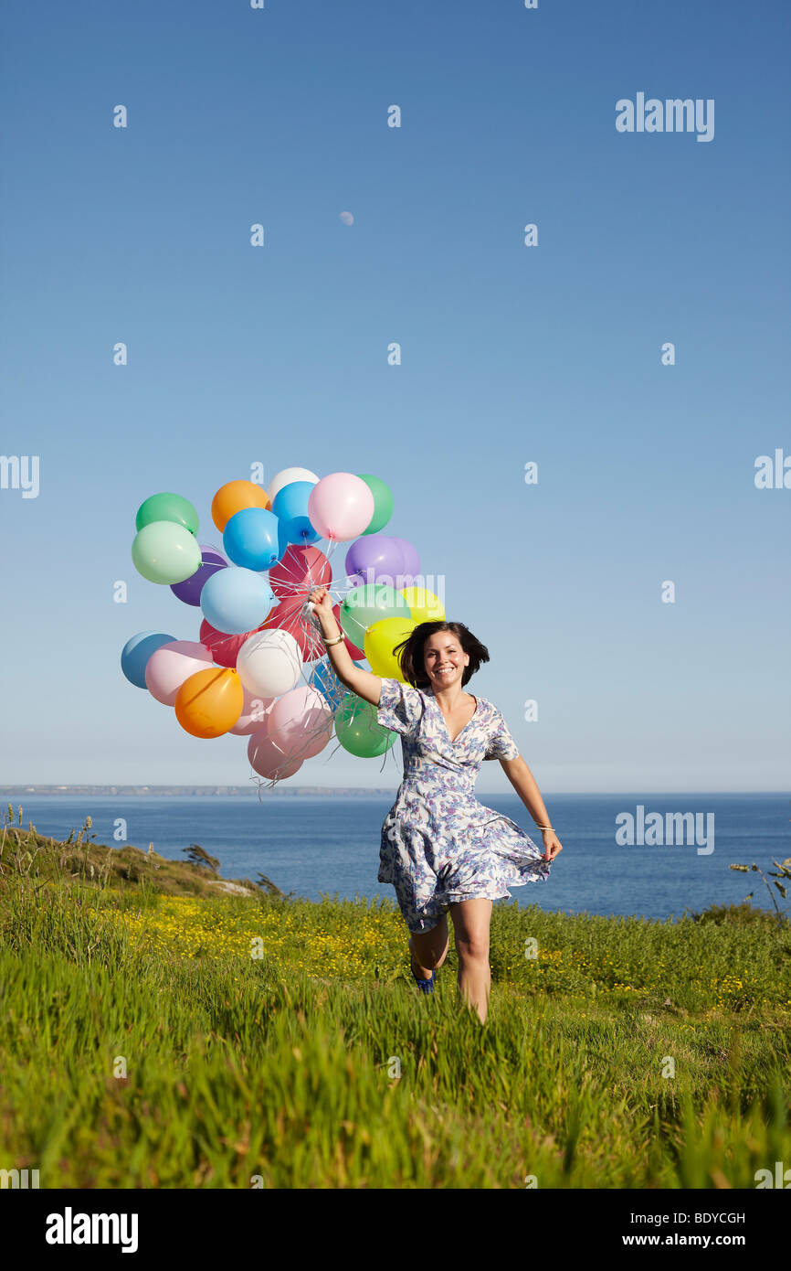 A girl running with balloons Stock Photo - Alamy