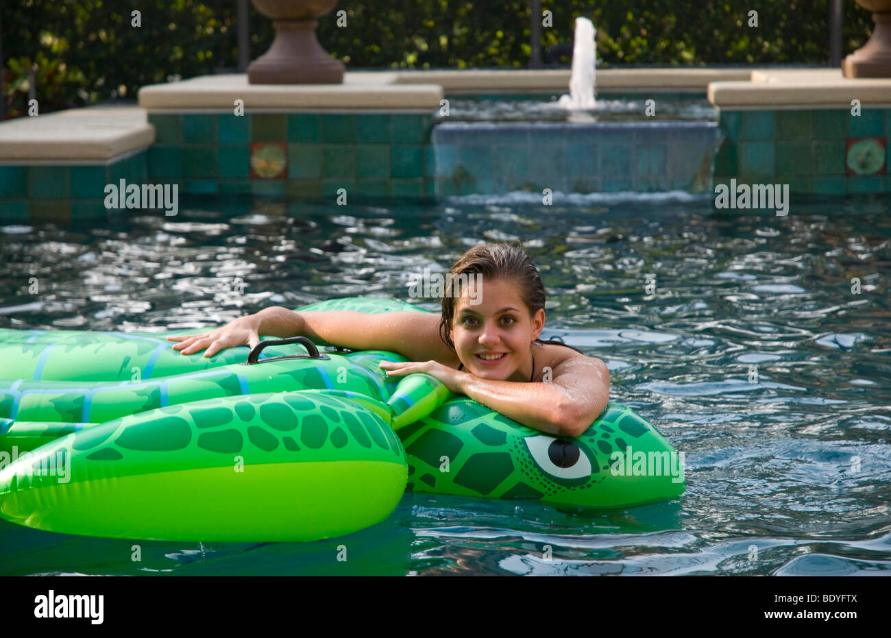 Young lady interacting with inflatable turtle in swimming pool Stock ...