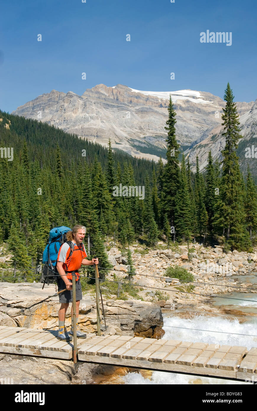 Backpacker crossing the bridge over Twin Falls Creek, Yoho National ...