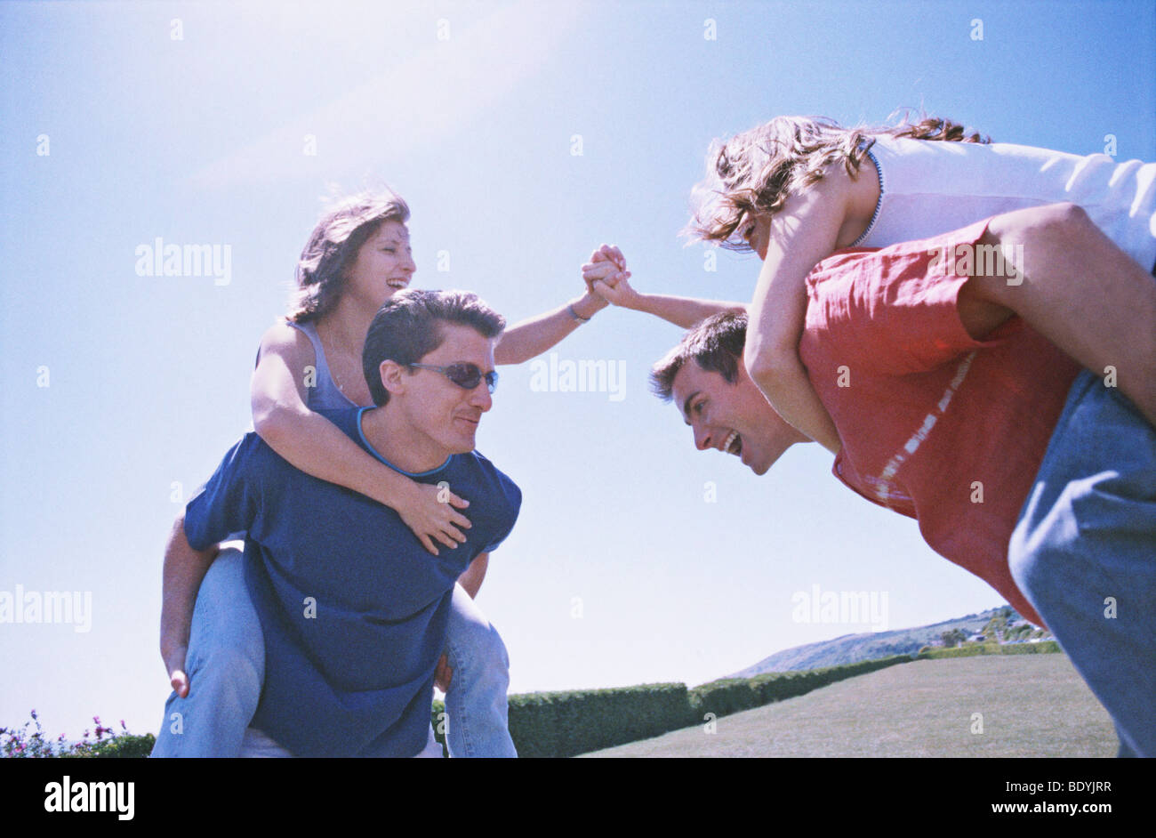 Two couples having fun in the park Stock Photo - Alamy