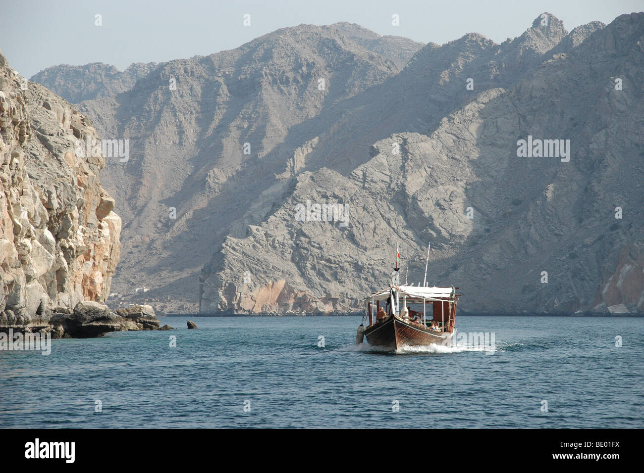 A dhow boat moving through the fjords of the Musandam Peninsula near ...