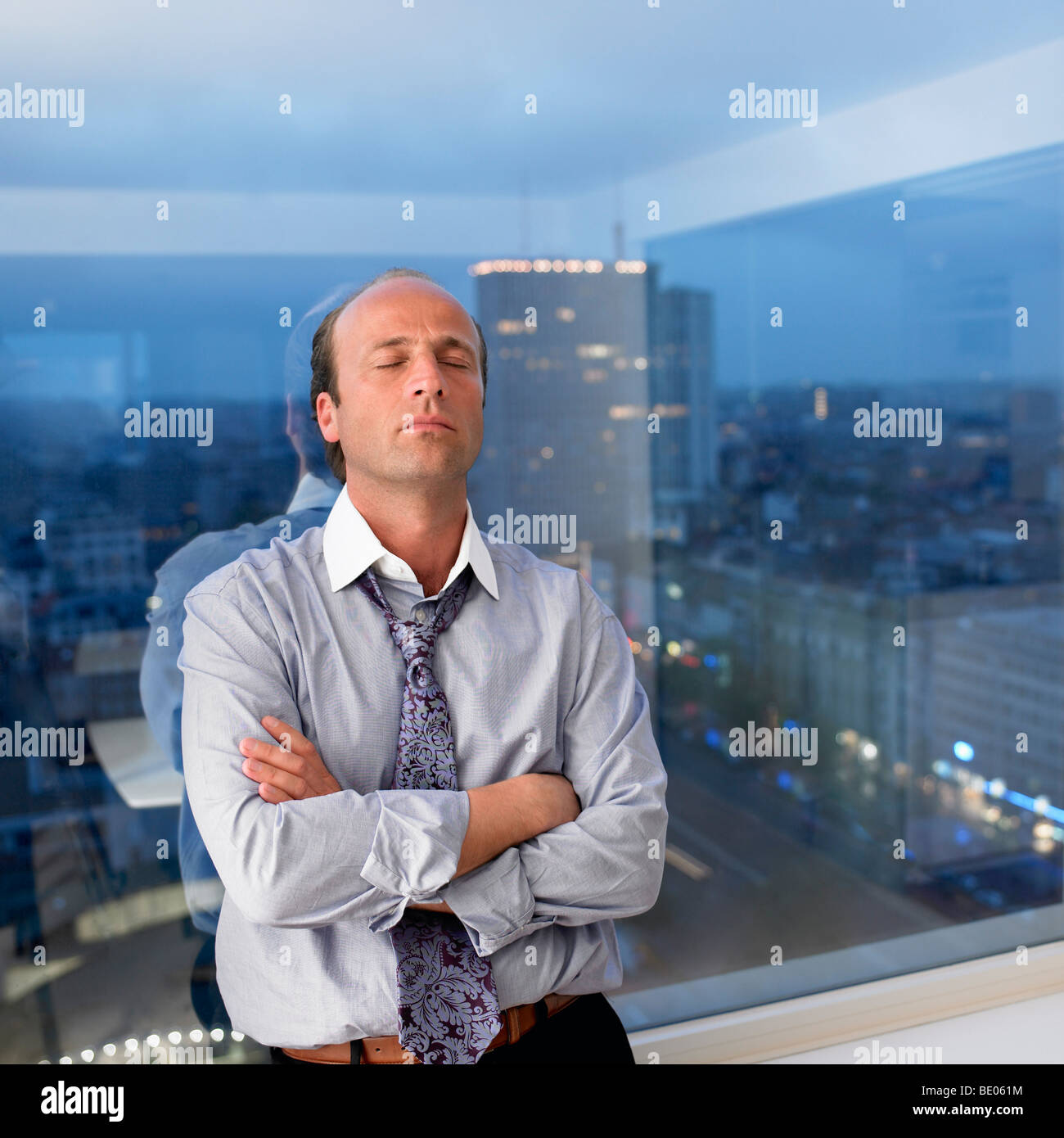 Business man leaning against the window Stock Photo - Alamy