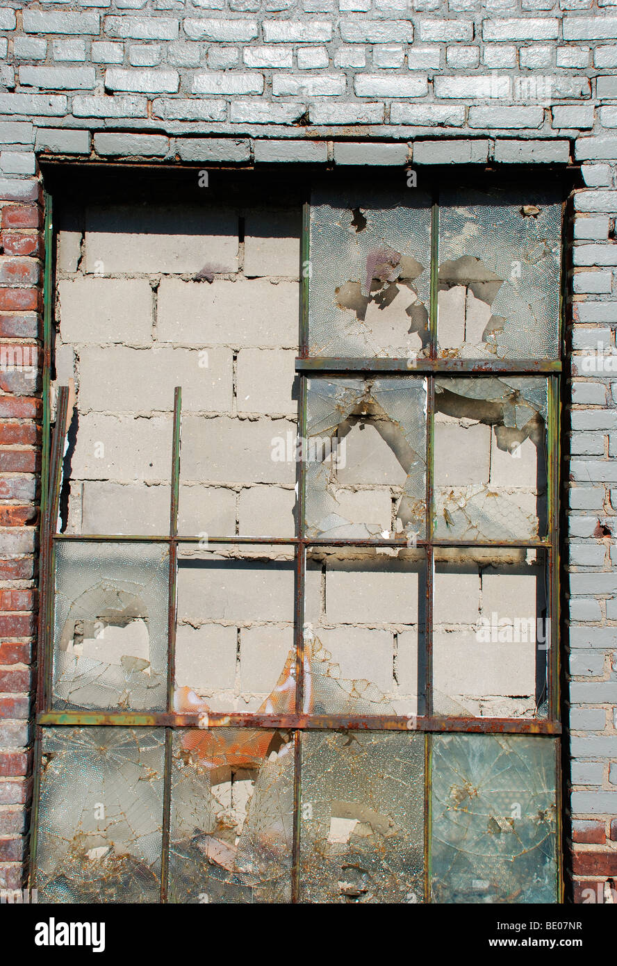 exterior of broken window closed up from the inside with concrete ...
