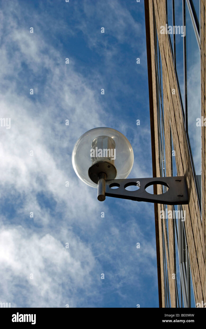 street light in spherical casing fixed to the side of a building, in ...