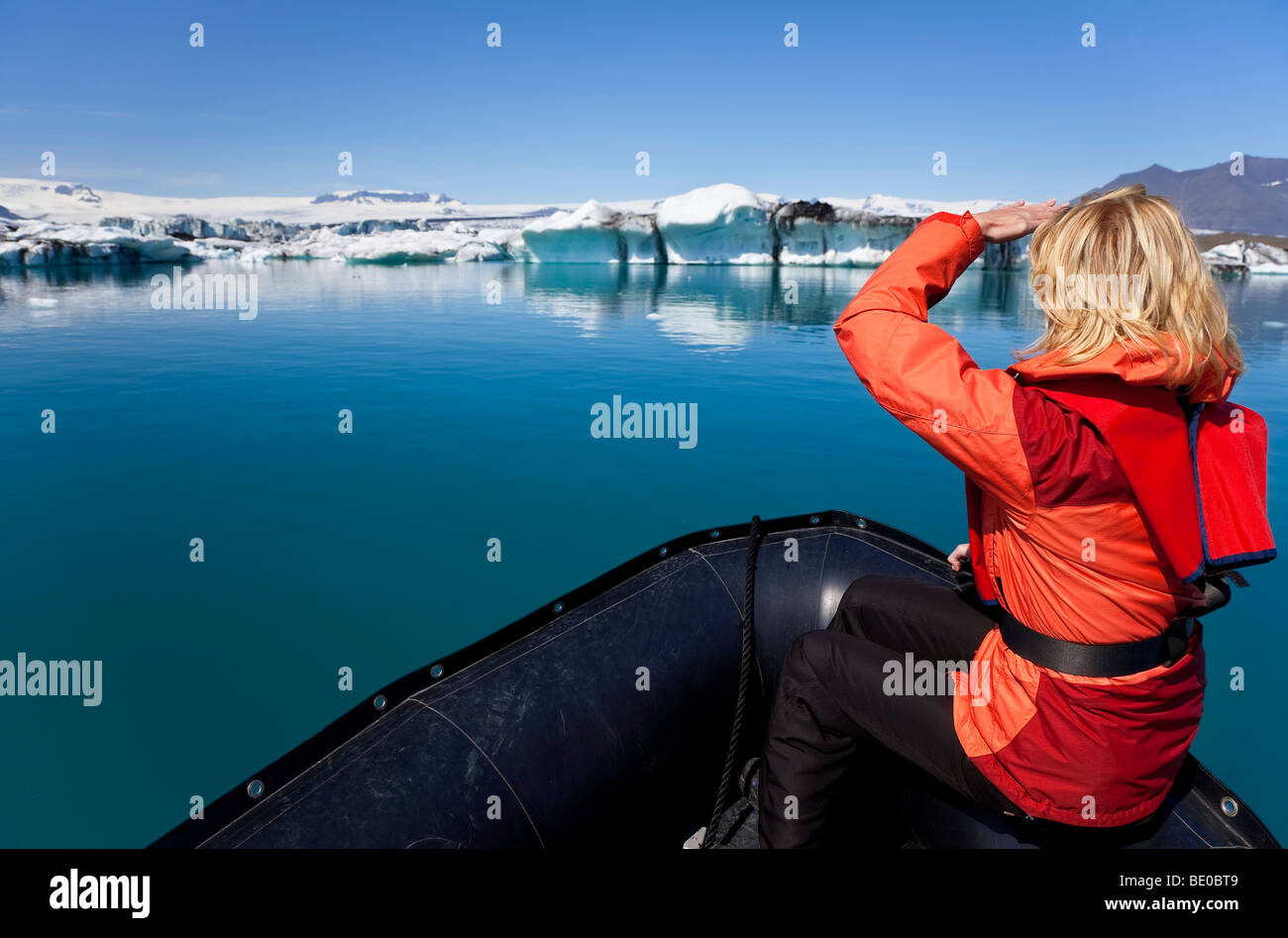 Woman explorer floating in a rigid inflatable boat through an iceberg ...