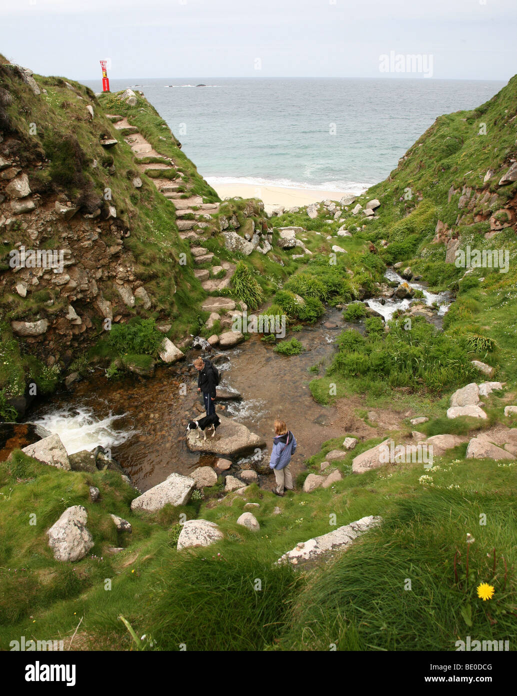 Two women walking over the steps and stream with stepping stones ...