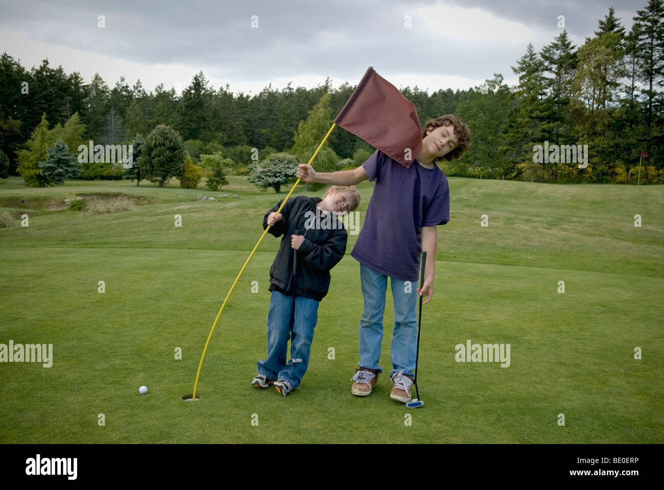 Two boys being playful on a golf course Stock Photo - Alamy
