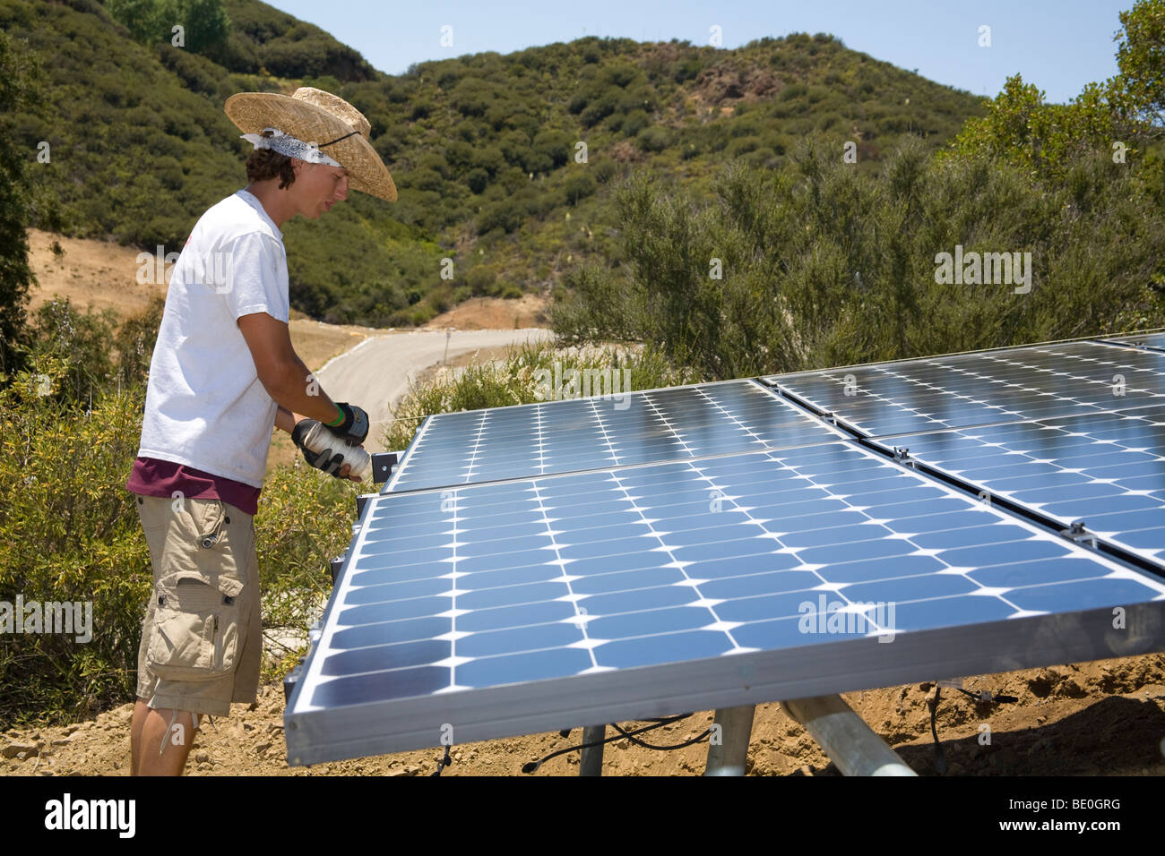 Workers install a solar array on a hillside in Malibu, California, USA ...