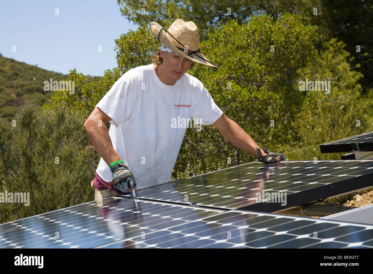 Workers install a solar array on a hillside in Malibu, California, USA ...