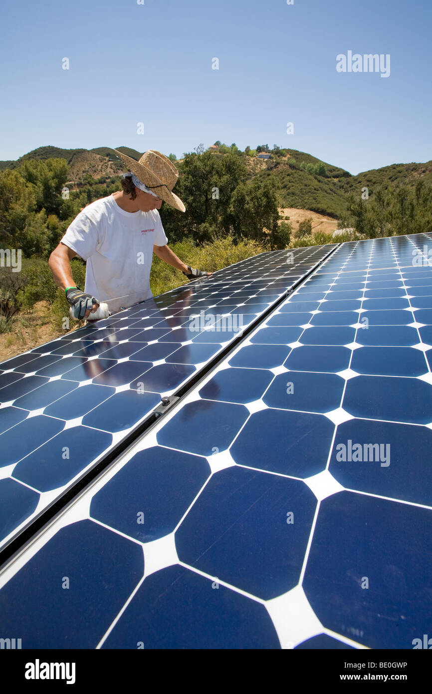 Workers install a solar array on a hillside in Malibu, California, USA ...