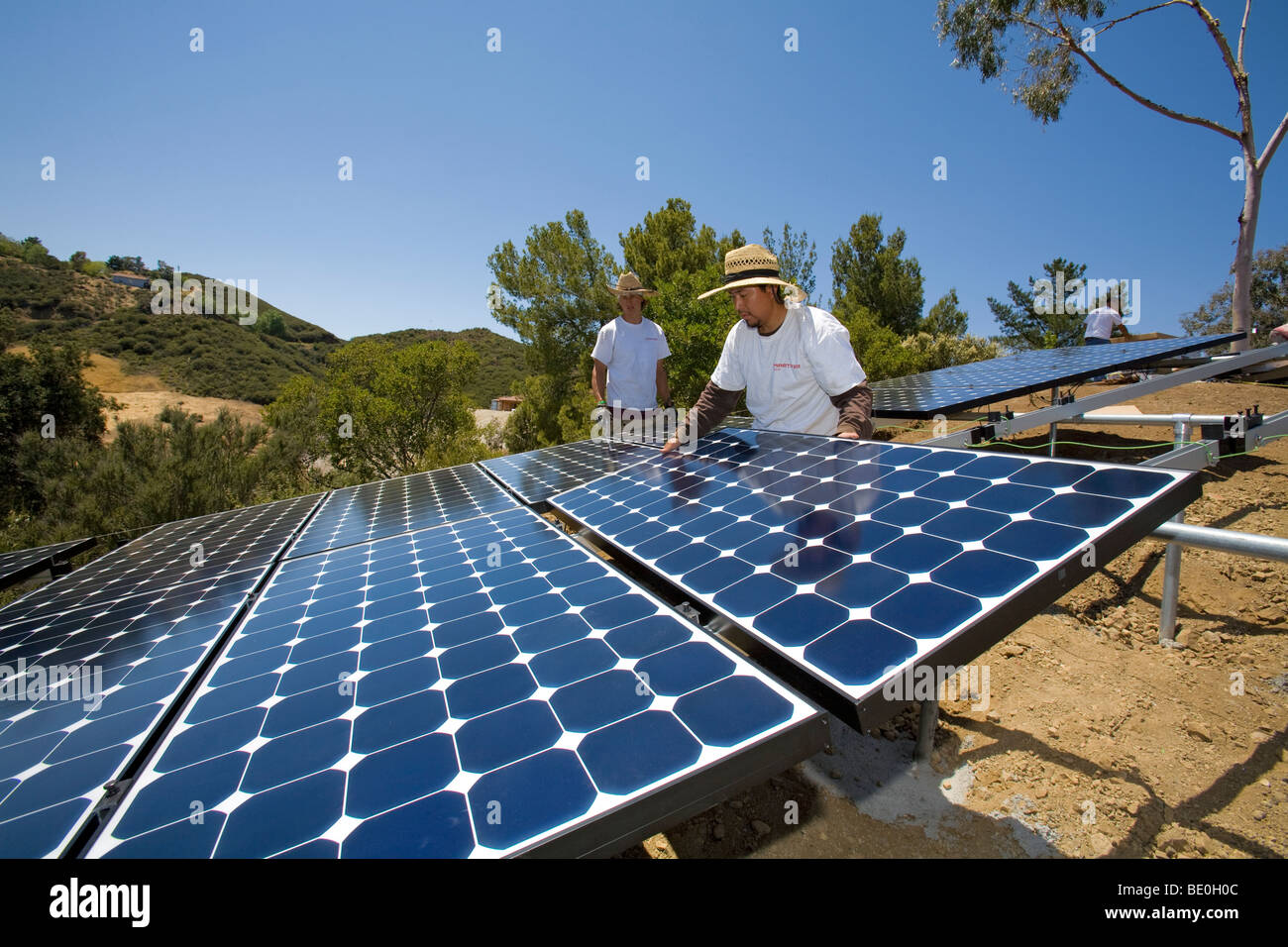 Workers install a solar array on a hillside in Malibu, California, USA ...