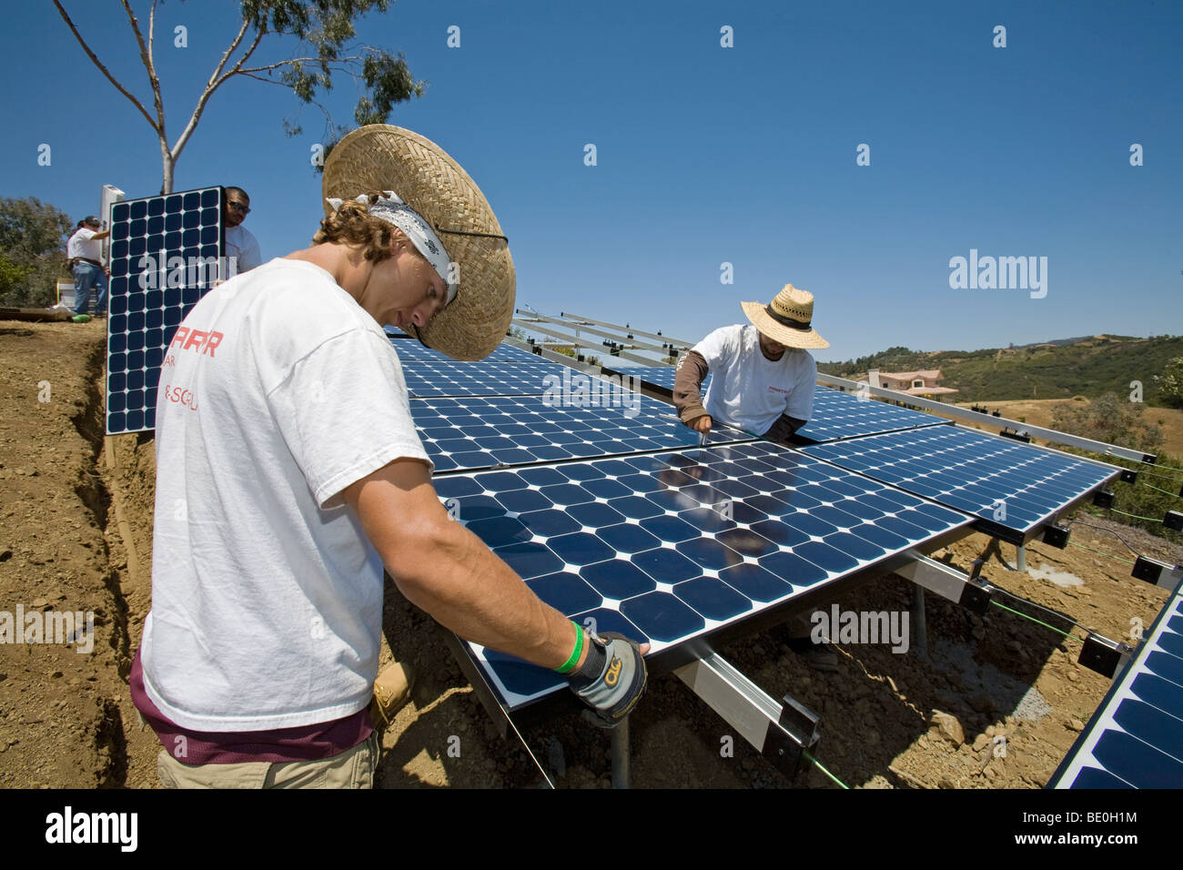 Workers install a solar array on a hillside in Malibu, California, USA ...