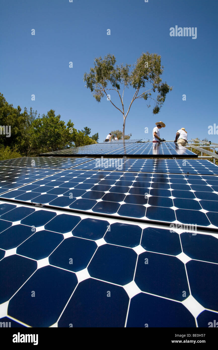 Workers install a solar array on a hillside in Malibu, California, USA ...