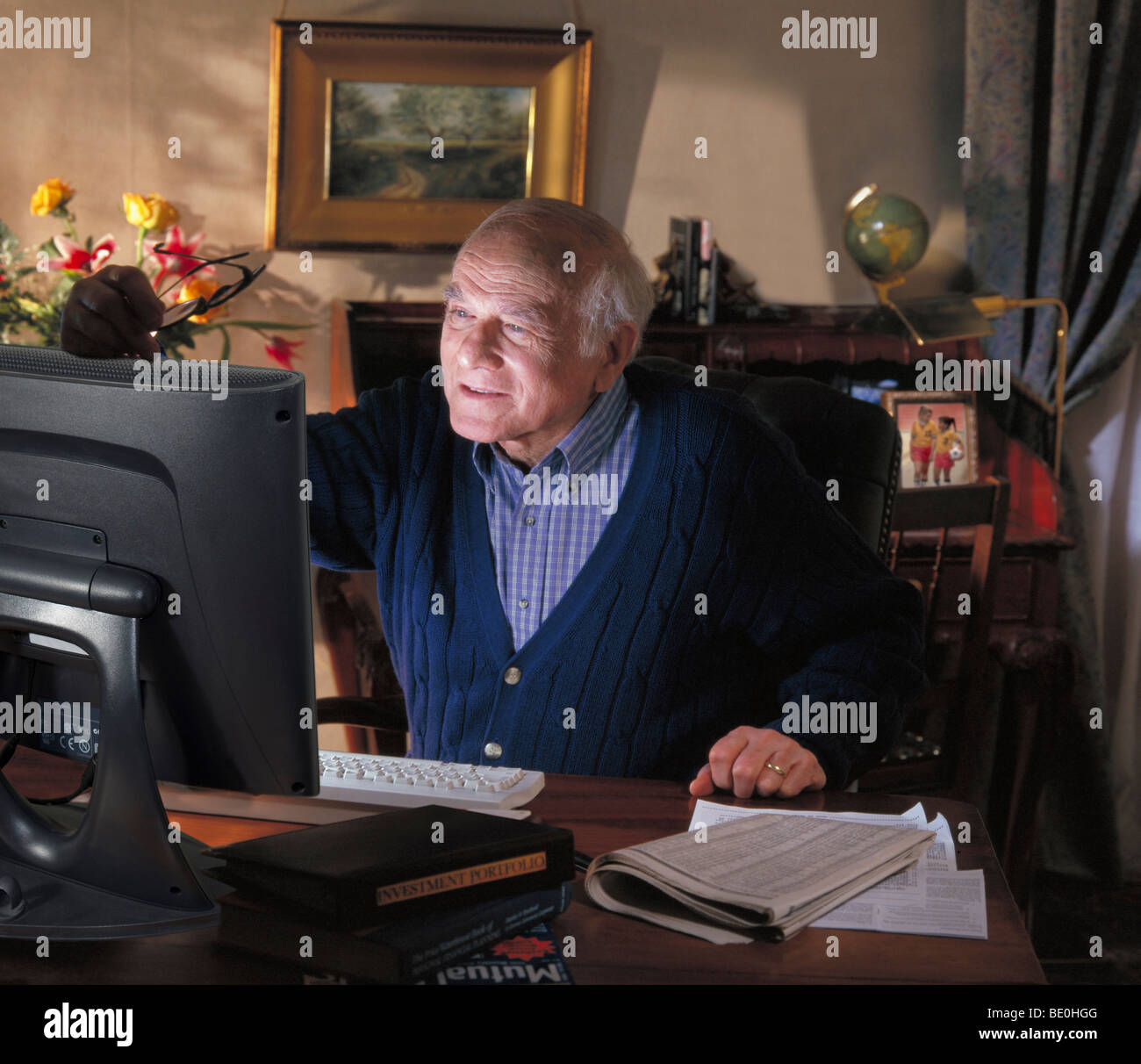 senior man looking at computer appearing content with investment ...