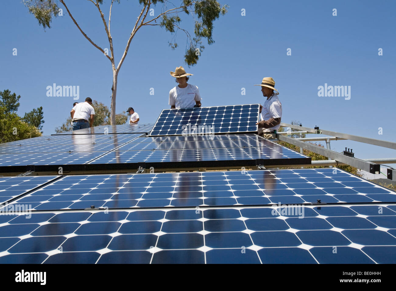 Workers install a solar array on a hillside in Malibu, California, USA ...